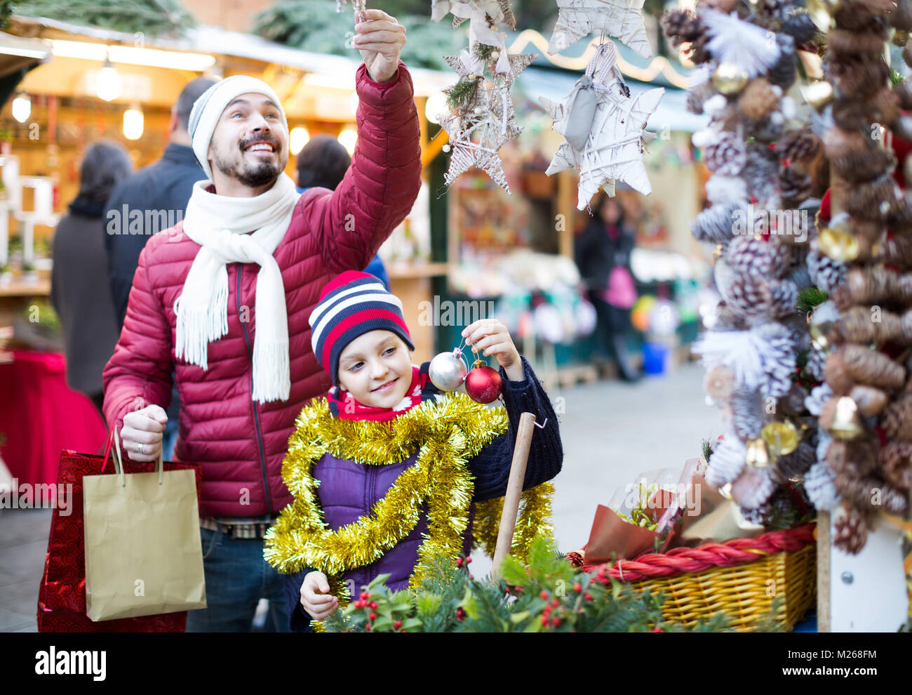 little girl with adult english dad buying decorations for Xmas. Focus ...