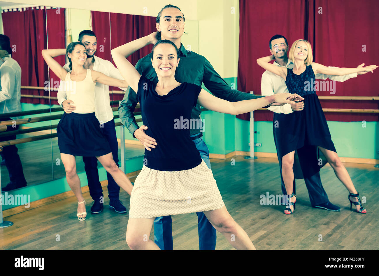 happy european men and women enjoying of tango in class Stock Photo - Alamy