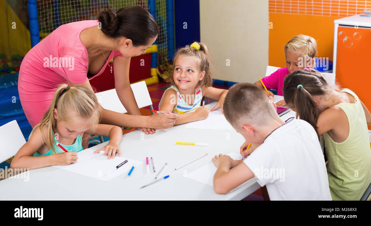 Smiling children drawing pencils on lesson in elementary school class ...