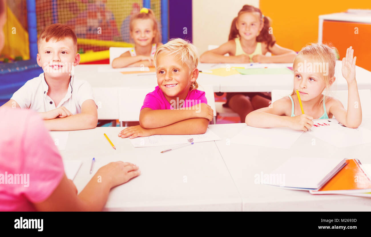 smiling spanish children sitting together and studying in class at ...