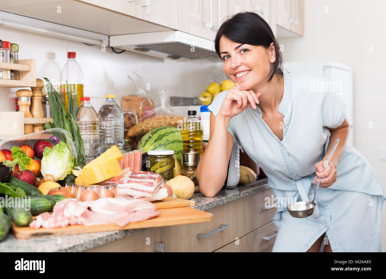 Cheerful woman is posing in time cooking on the kitchen at home Stock ...
