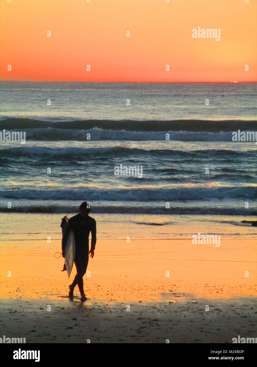 Surfer at sunset Stock Photo - Alamy