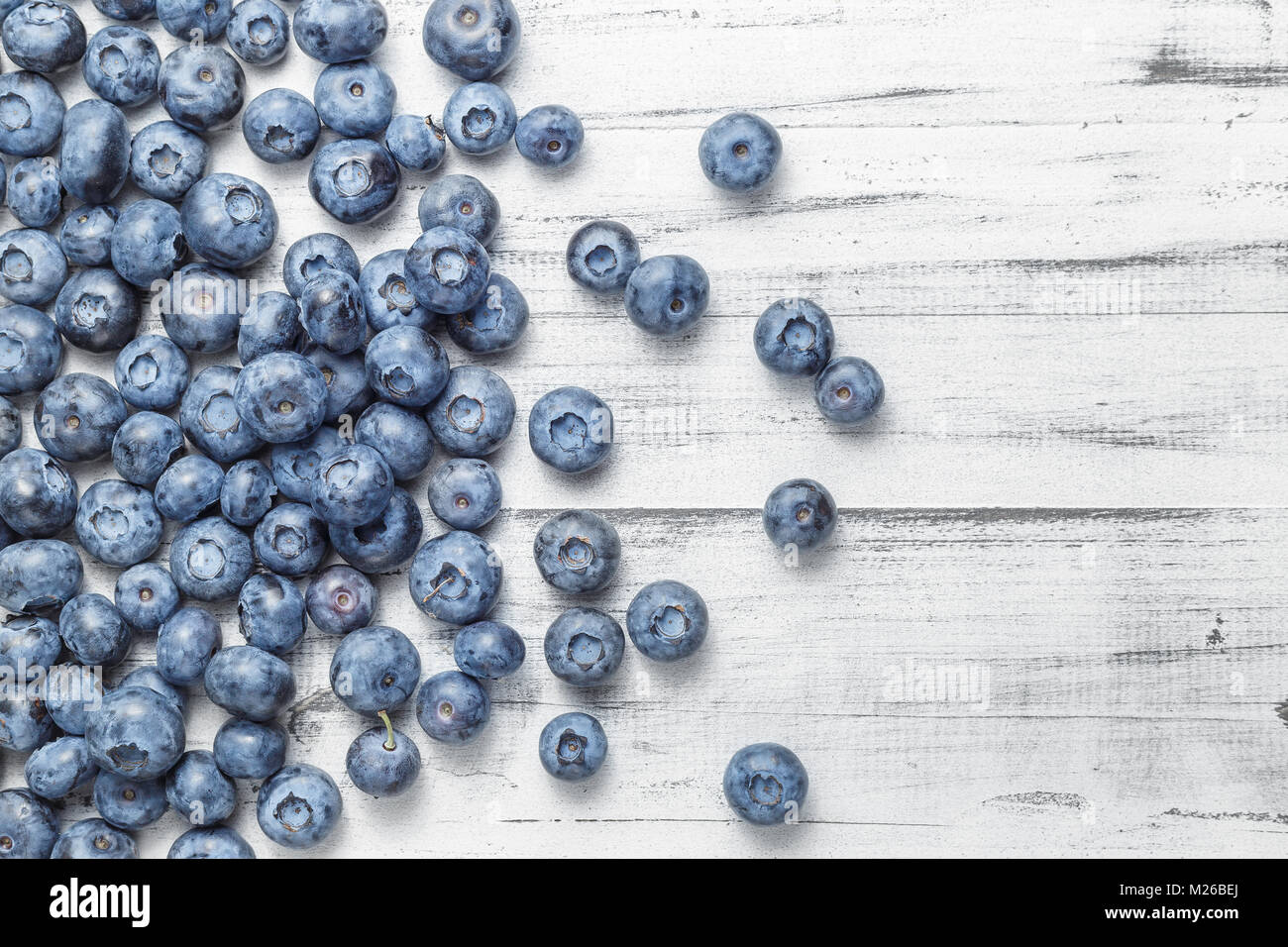 American blueberry border. Blueberries scattered over white wooden ...