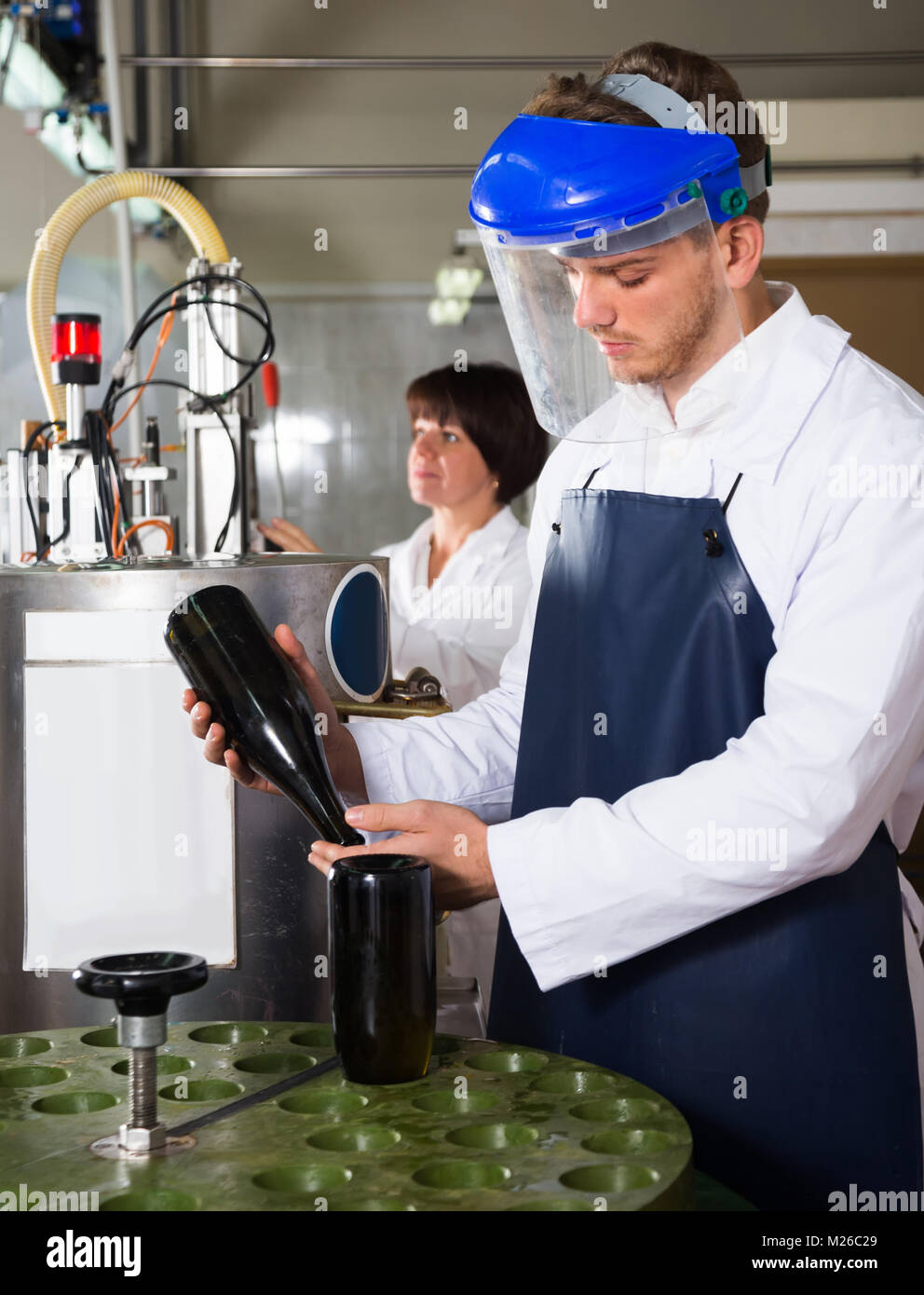 positive spanish adult male employee operating machine at sparkling ...