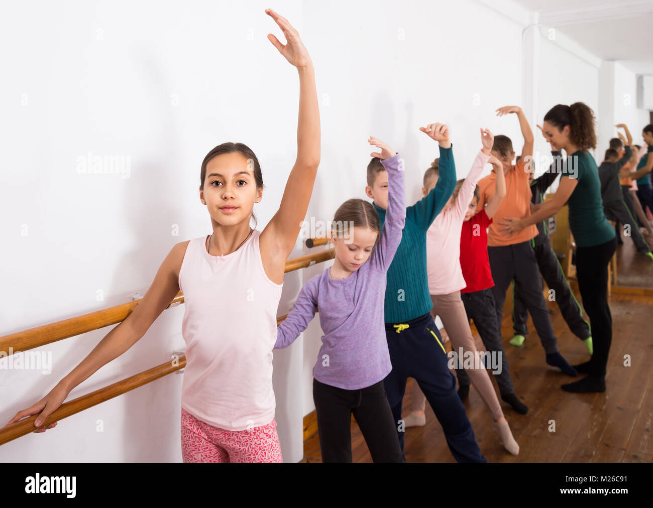 Group of happy children practicing at the ballet barre Stock Photo - Alamy