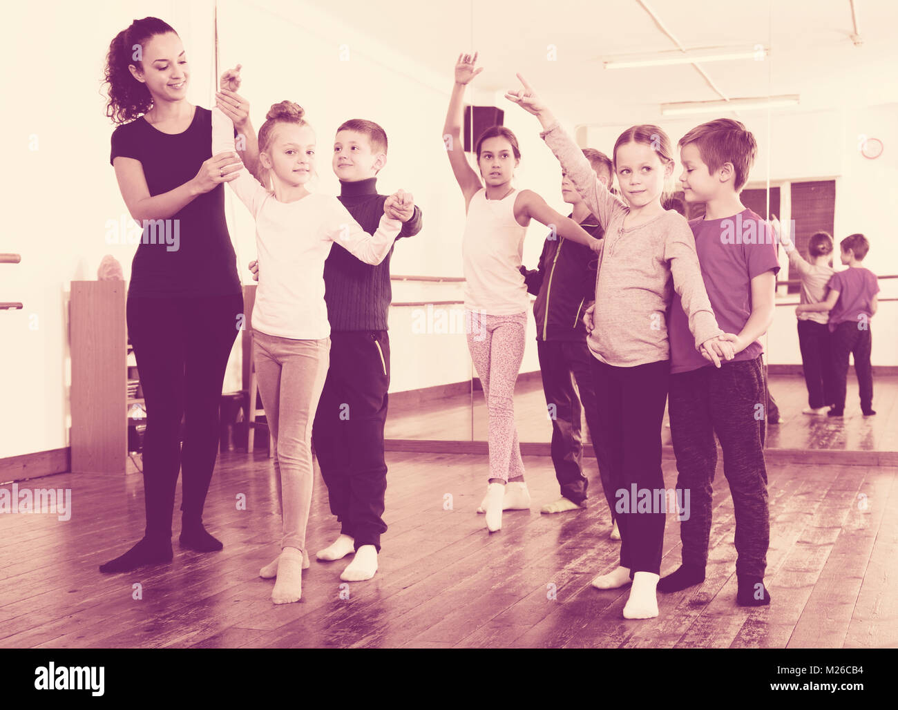 Positive little boys and beautiful girls having dancing class Stock ...