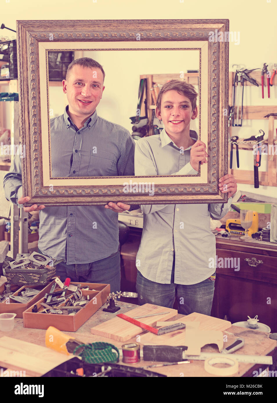 portrait of happy russian man and boy choosing tight wooden bar in ...