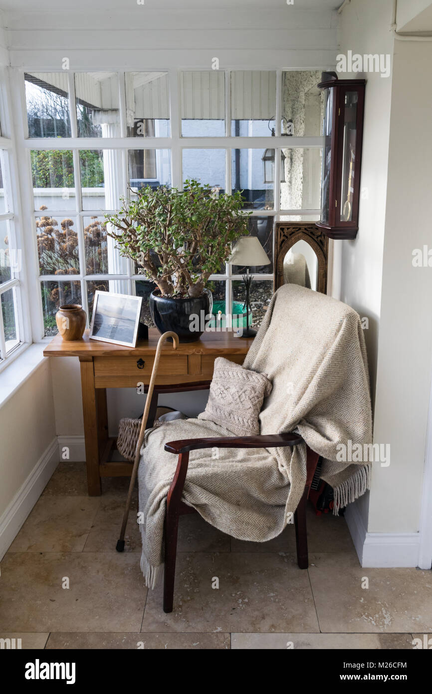 Empty comfortable chair on a porch with a blanket coving it and a ...
