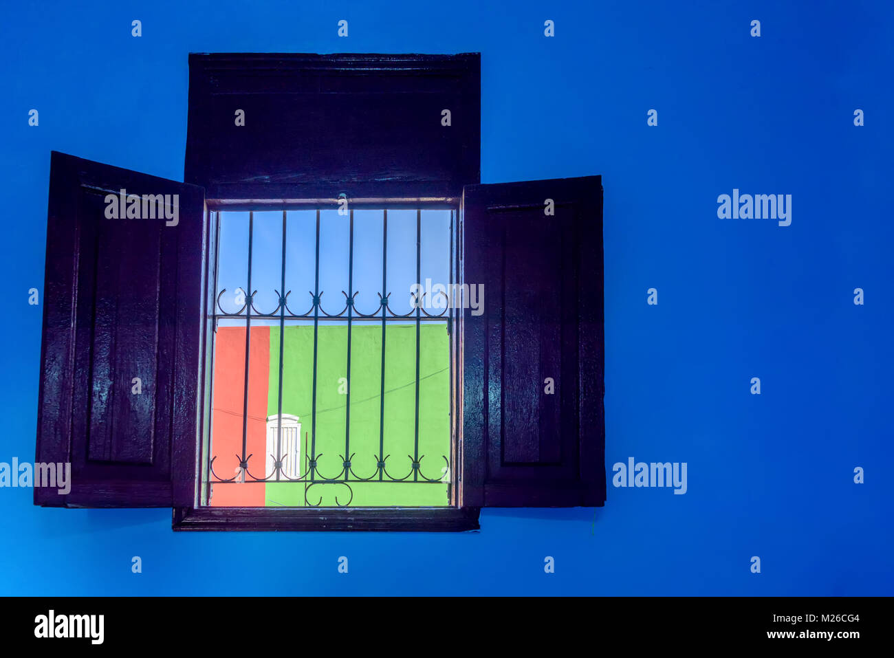 A typical Cuban window with a lattice and a view of the red-green wall ...