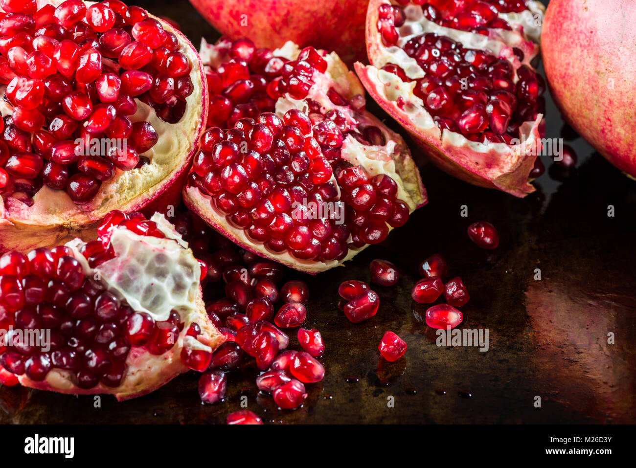 Ripe Open Pomegranate on dark rustic background Stock Photo - Alamy