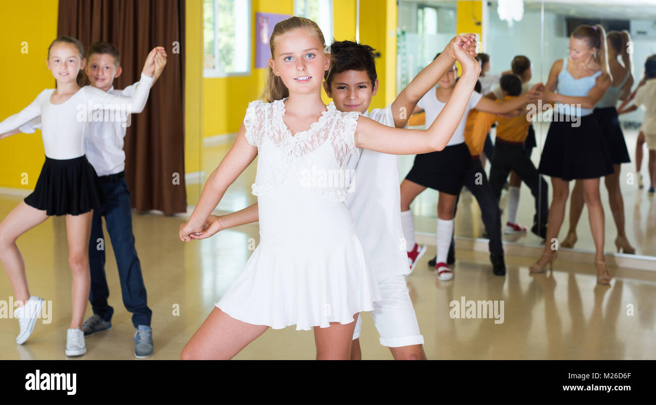 Portrait of glad young children enjoying of partner dance in class ...