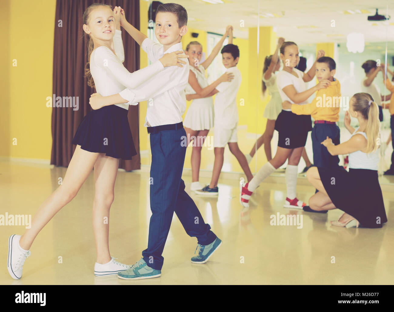 Diligent smiling positive boys and girls having dancing class in ...