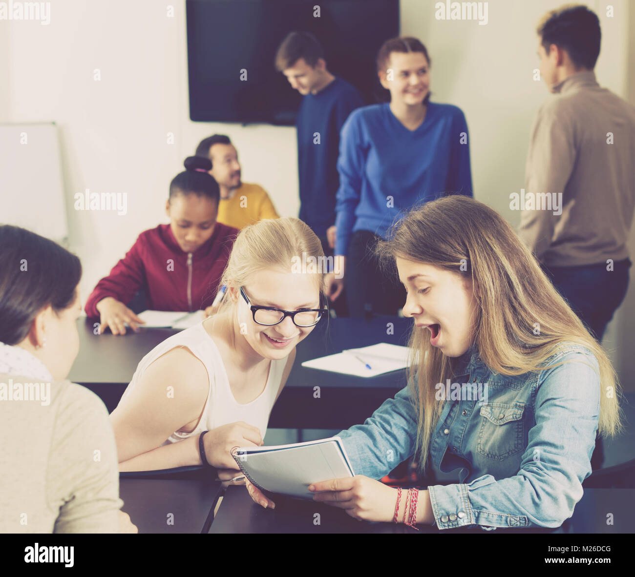 serious classmates having animated talks at break between classes sits ...