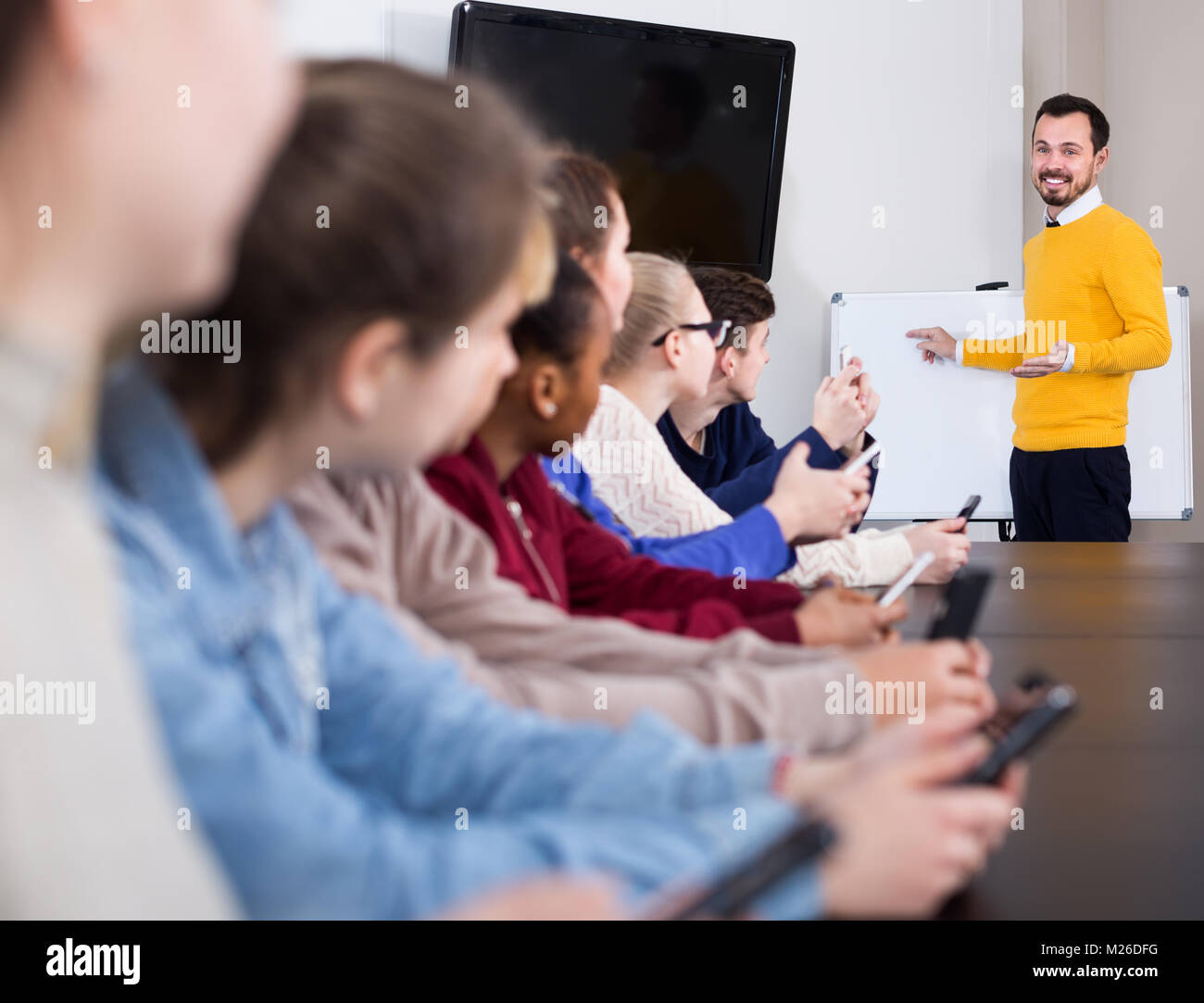 male and female students following explanations of vigorous teacher in ...