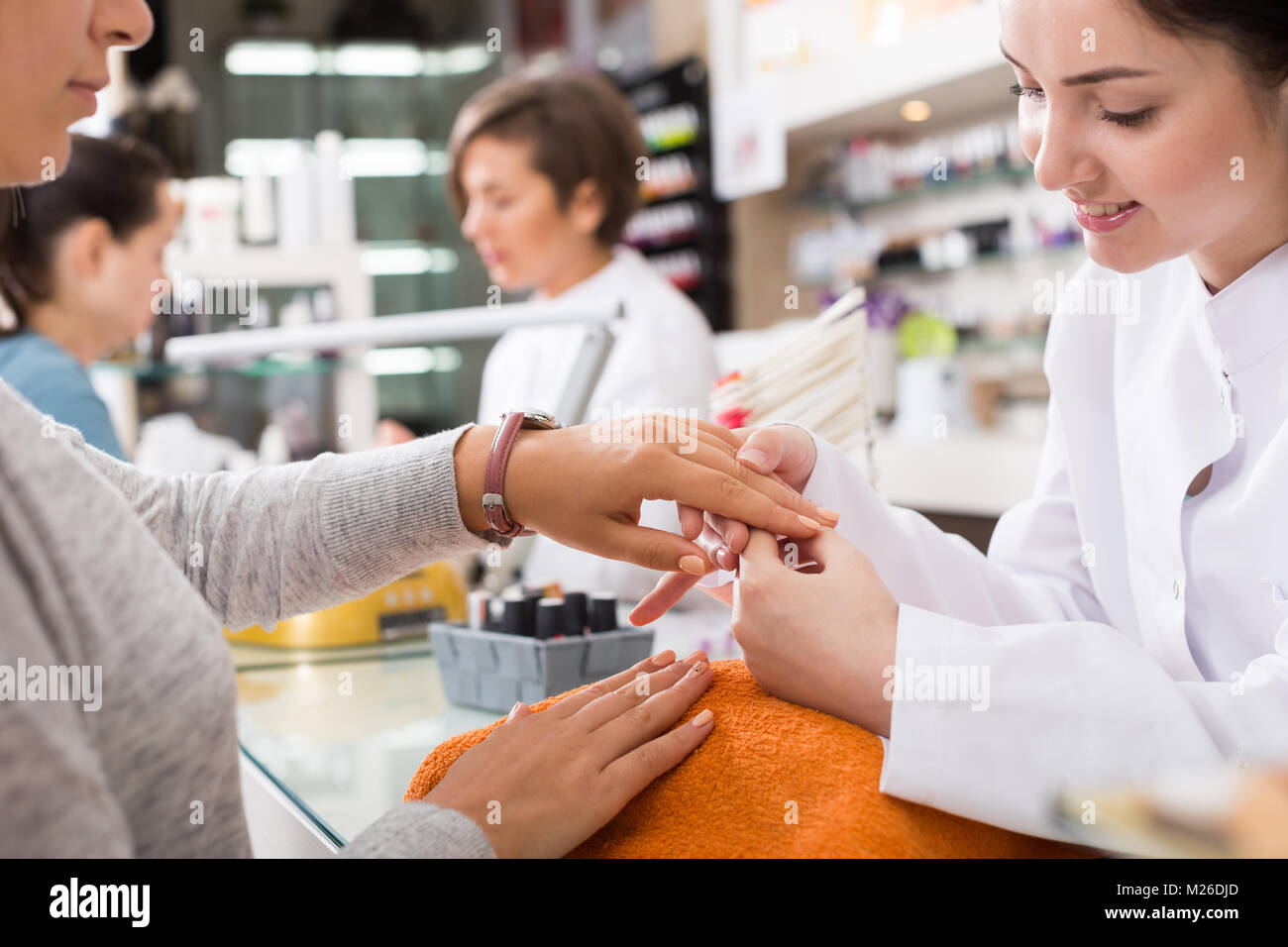 Nail masters performing manicure and massage in beauty salon Stock ...