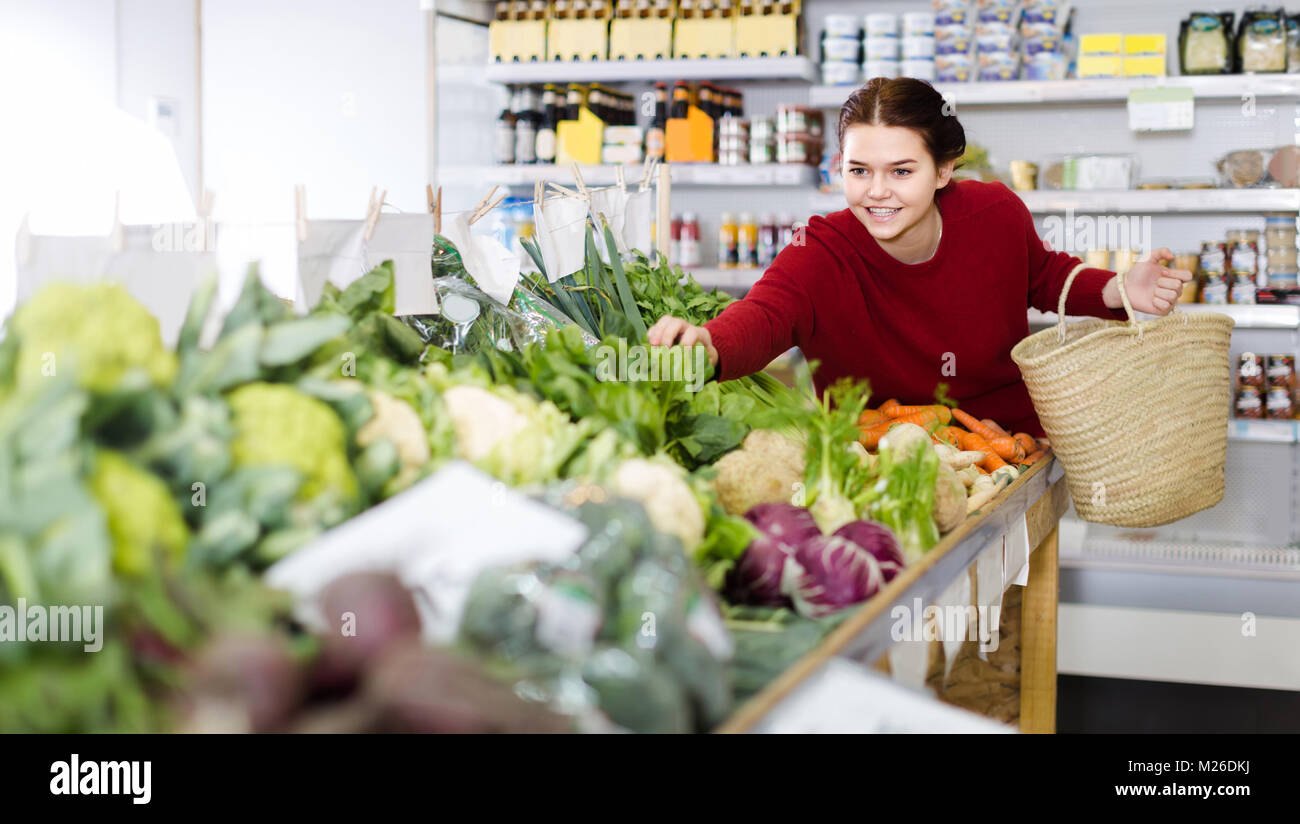 Portrait of happy spanish young female customer in grocery Stock Photo ...