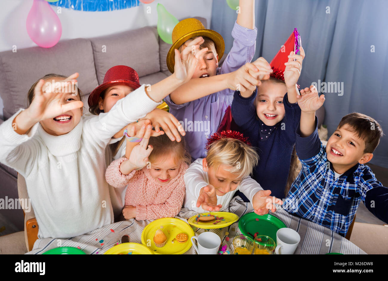 Positive smiling boys and girls behaving jokingly during friend’s ...
