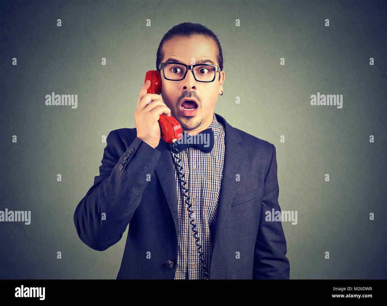 Formal young man having breaking news while speaking on phone Stock ...