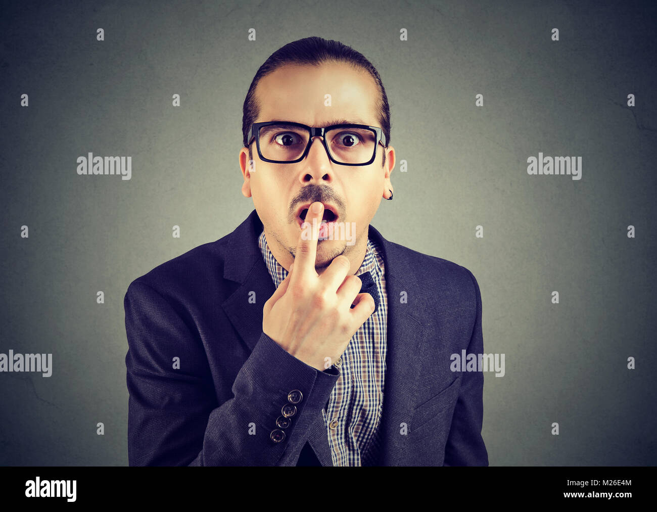 Young elegant man touching lips looking shocked at camera under great ...