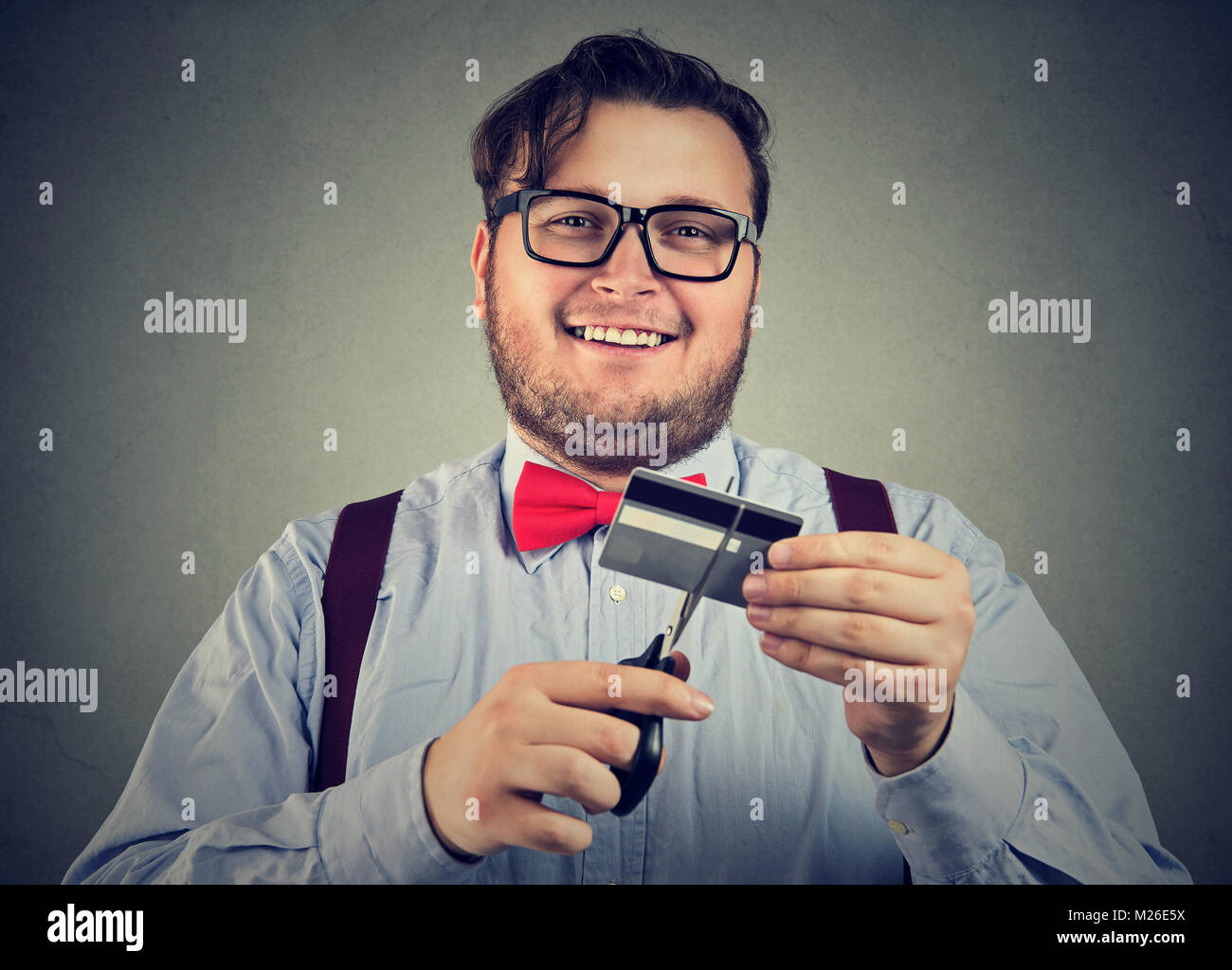 Cheerful chunky man cutting credit card paying out all debts Stock ...