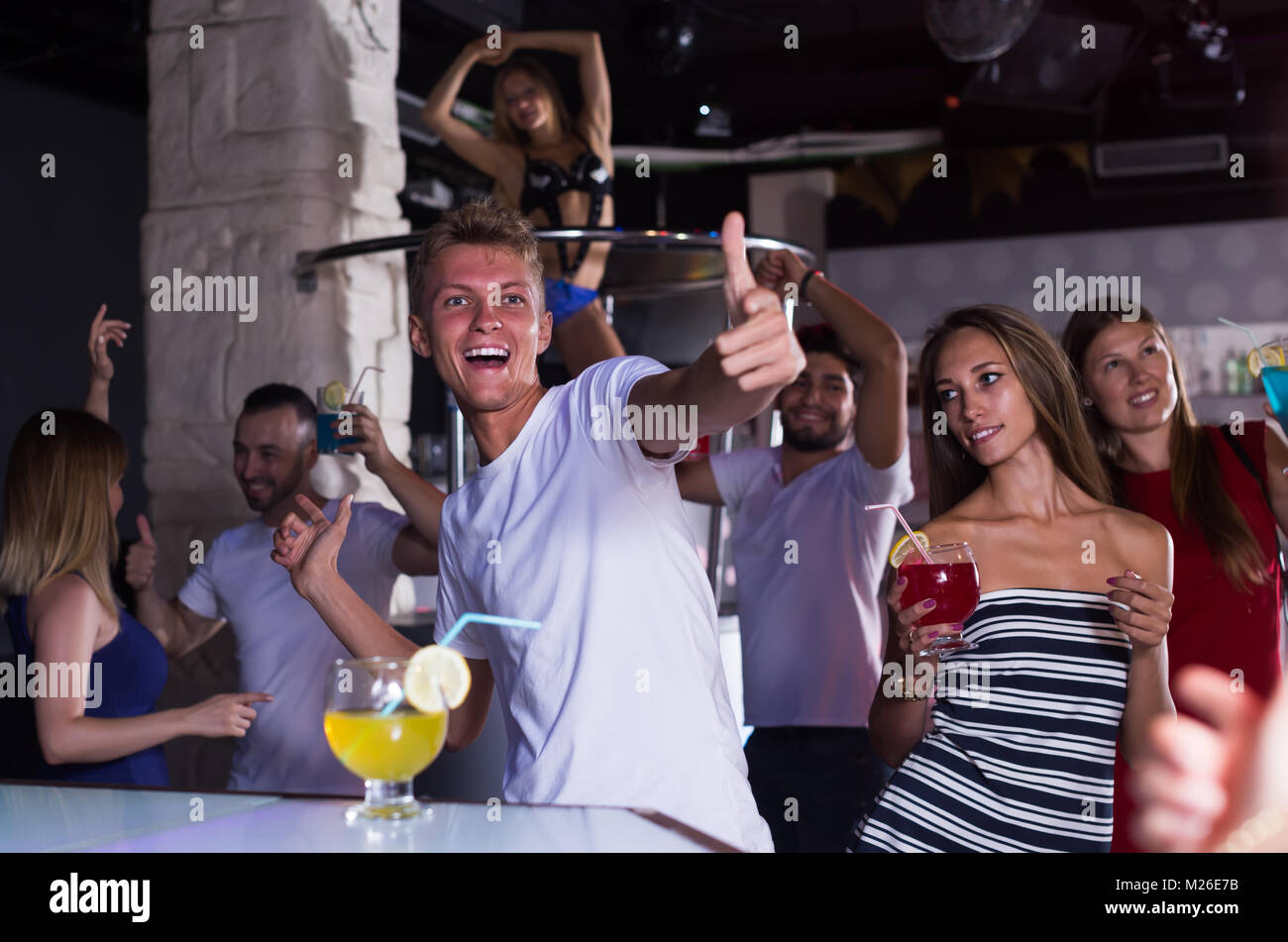 positive man joying and thumbs up on party in the club with cocktail ...