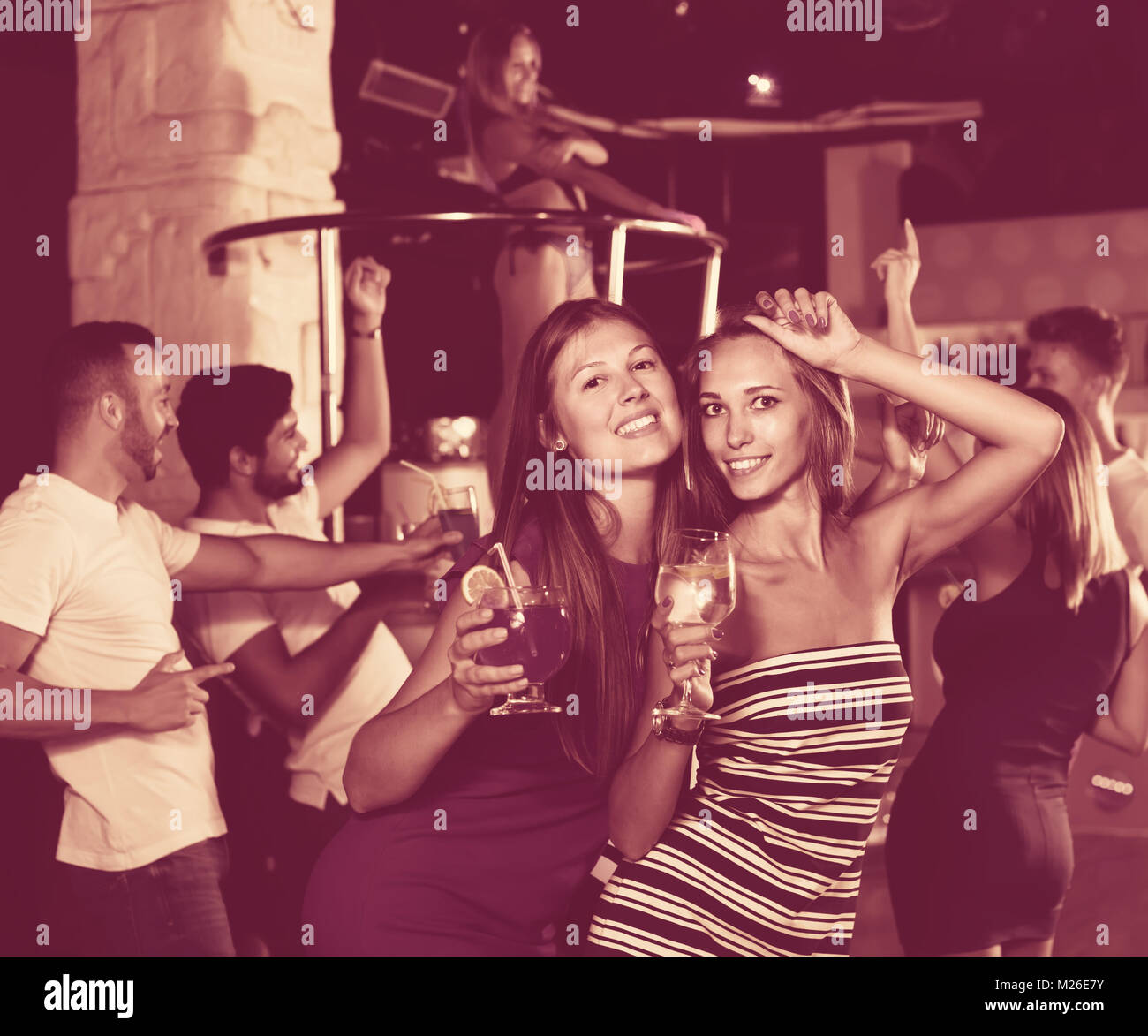 smiling women dancing in the night club with drinks in the hand Stock ...