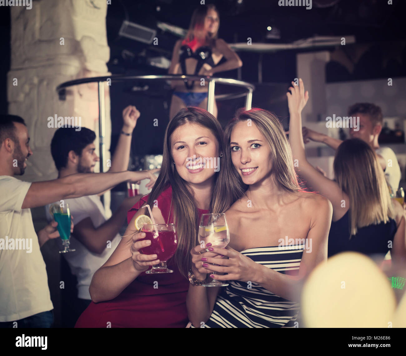 smiling females dancing in the night club with drinks in the hand Stock ...