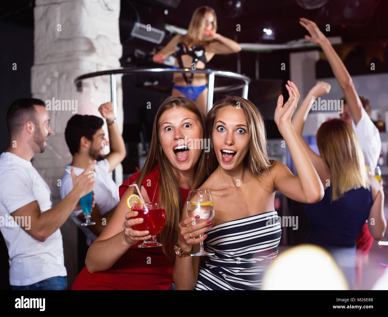 Cheerful positive smiling females friends with cocktail dancing in the ...