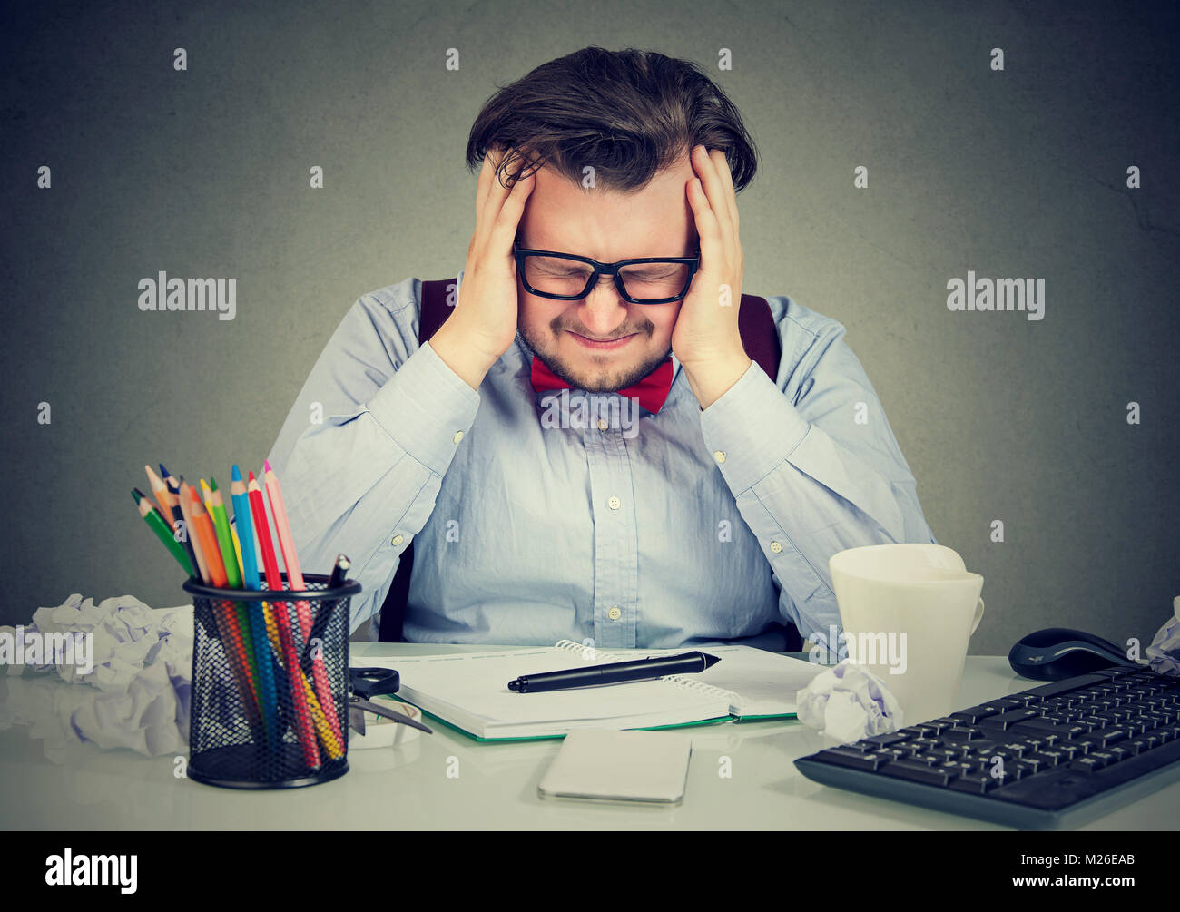 Chunky man in eyeglasses rubbing temples looking burnout while working ...