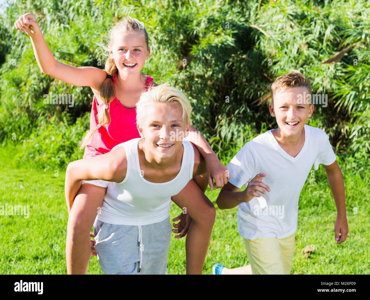 Group of laughing kids running happily together on grass Stock Photo ...