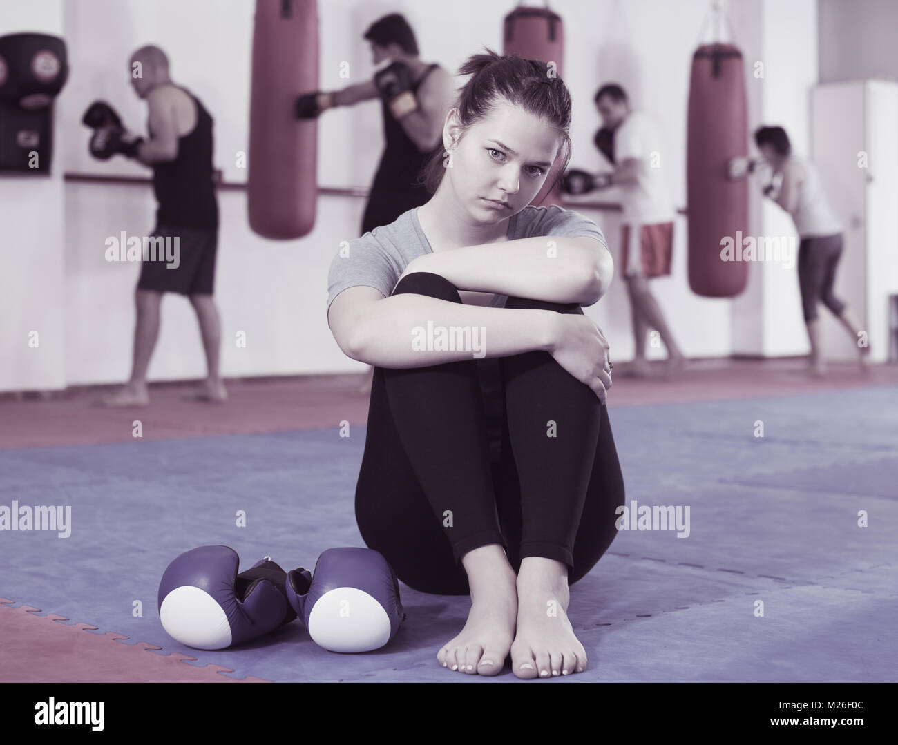 Loser girl failed and sitting on the floor in the boxing hall Stock ...