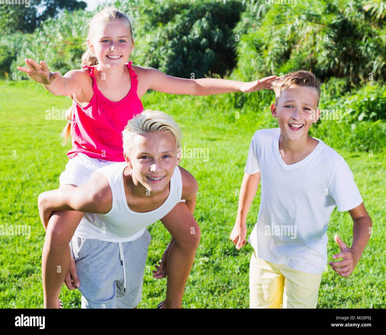 Group of laughing kids running happily together on grass Stock Photo ...