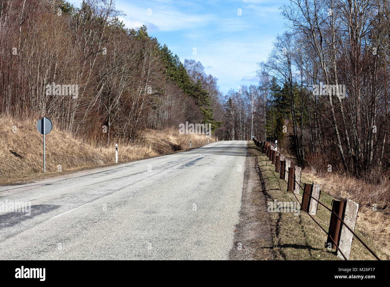 Empty country road with old rusty barrier in early spring Stock Photo ...