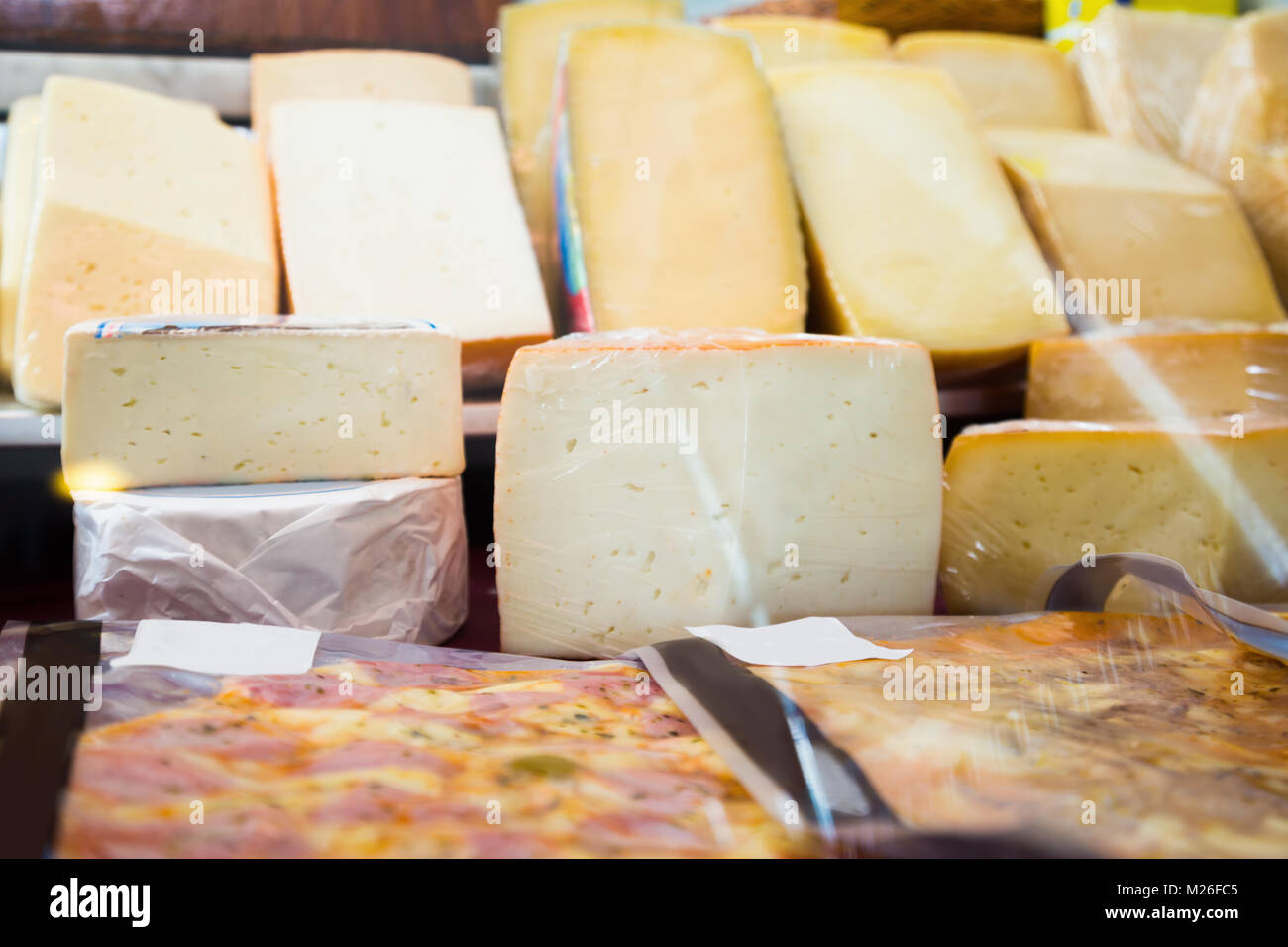 Cheese collection on counter of grocery shop Stock Photo - Alamy