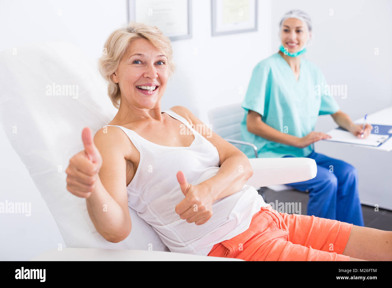 Smiling female patient satisfied after cosmetological procedure in ...