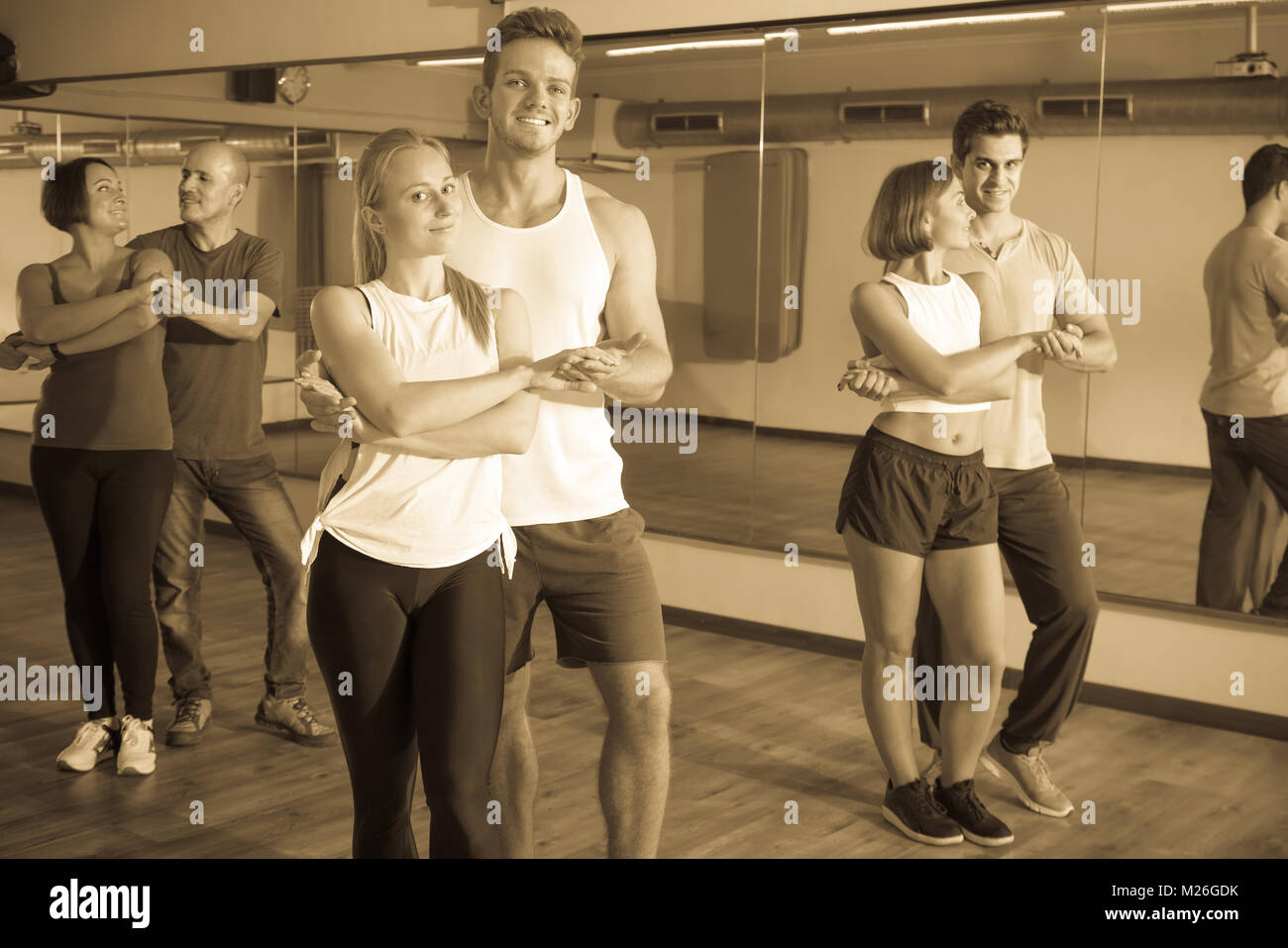 Laughing adults dancing bachata together in dance studio Stock Photo ...