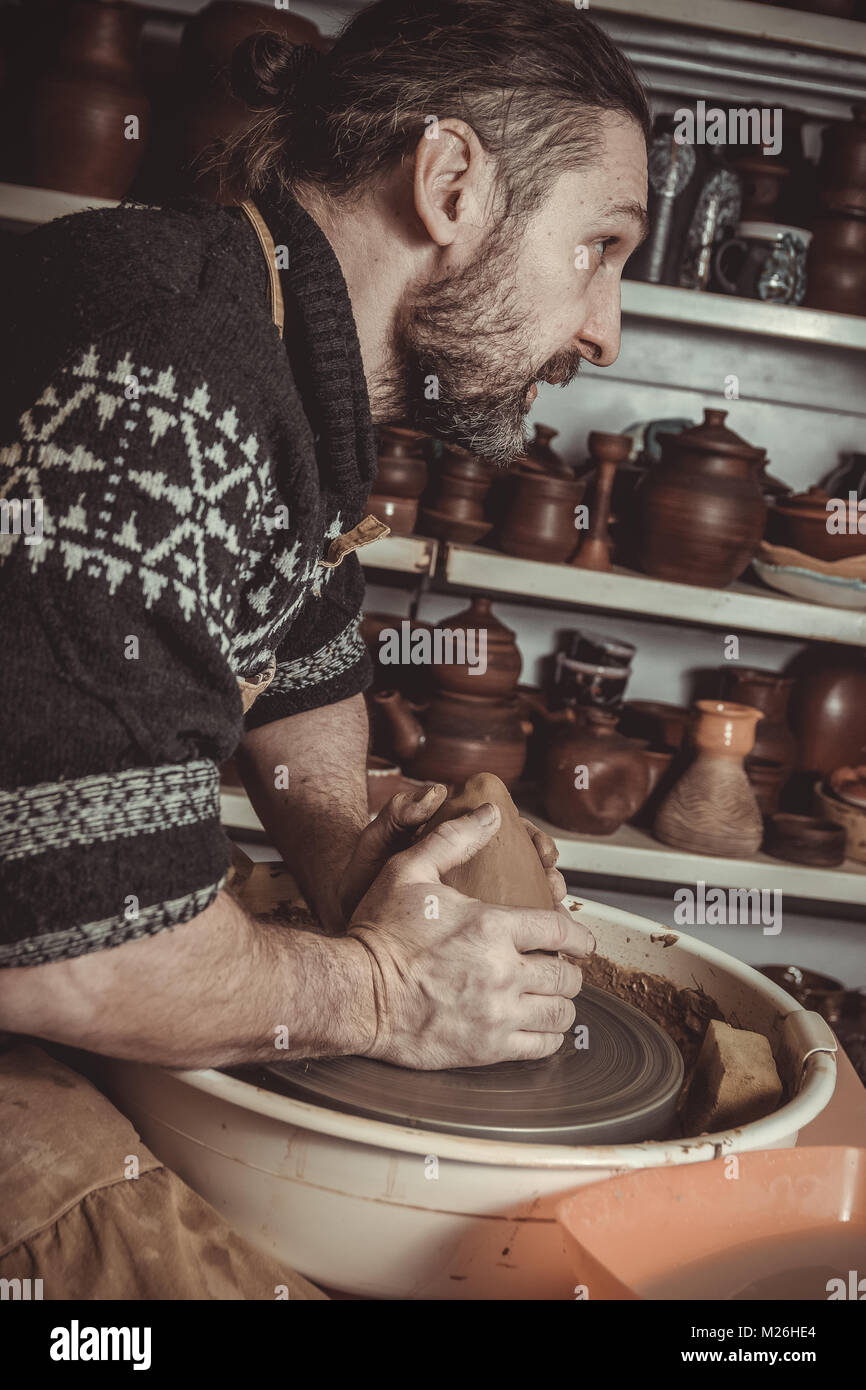 Adult male potter master mashing the clay Stock Photo - Alamy
