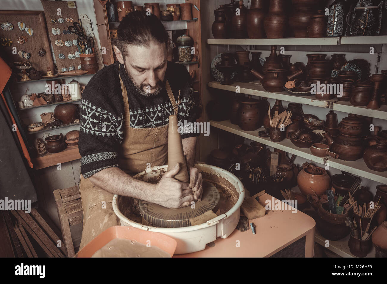 Adult male potter master mashing the clay Stock Photo - Alamy