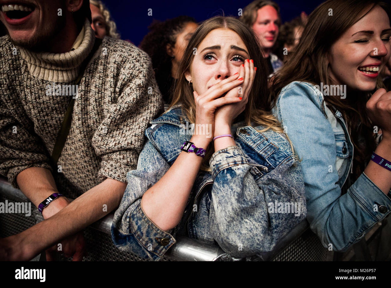 A music fan gets emotional among the concert crowds at a concert with ...