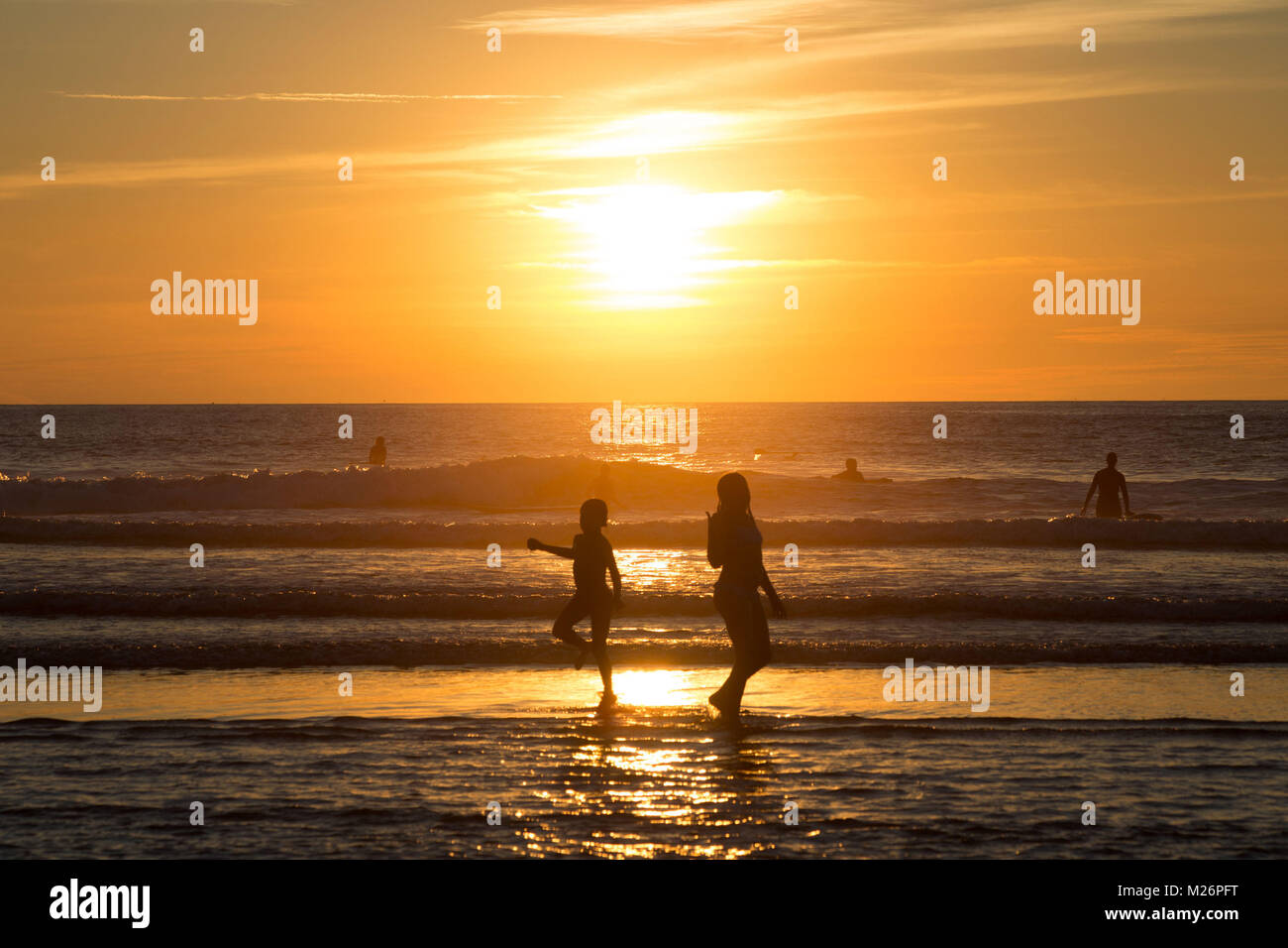 Silhouettes of people playing on a beach of the Basque coast in the ...