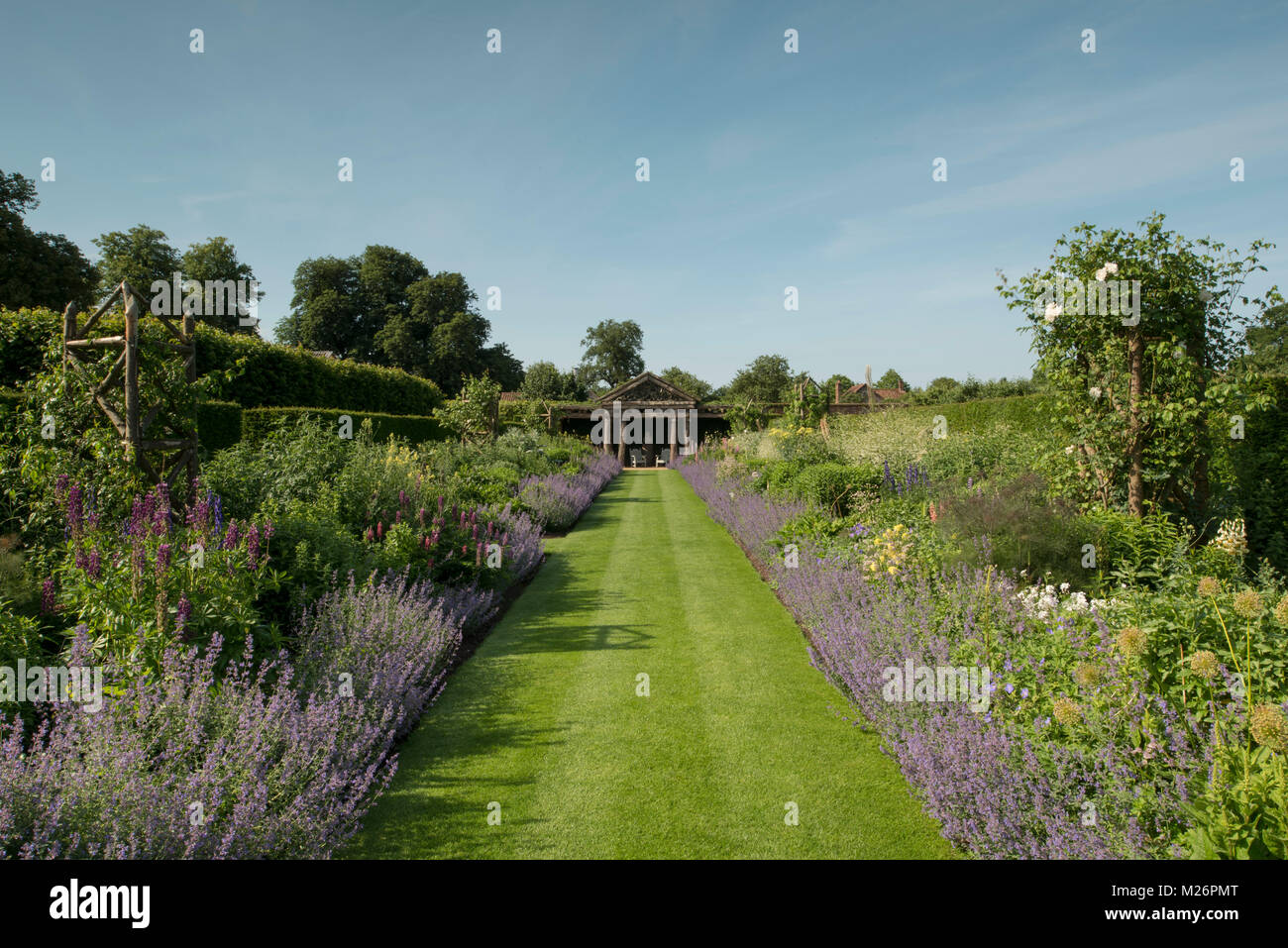 A view over the long borders leading to the Rustic Temple in the walled ...