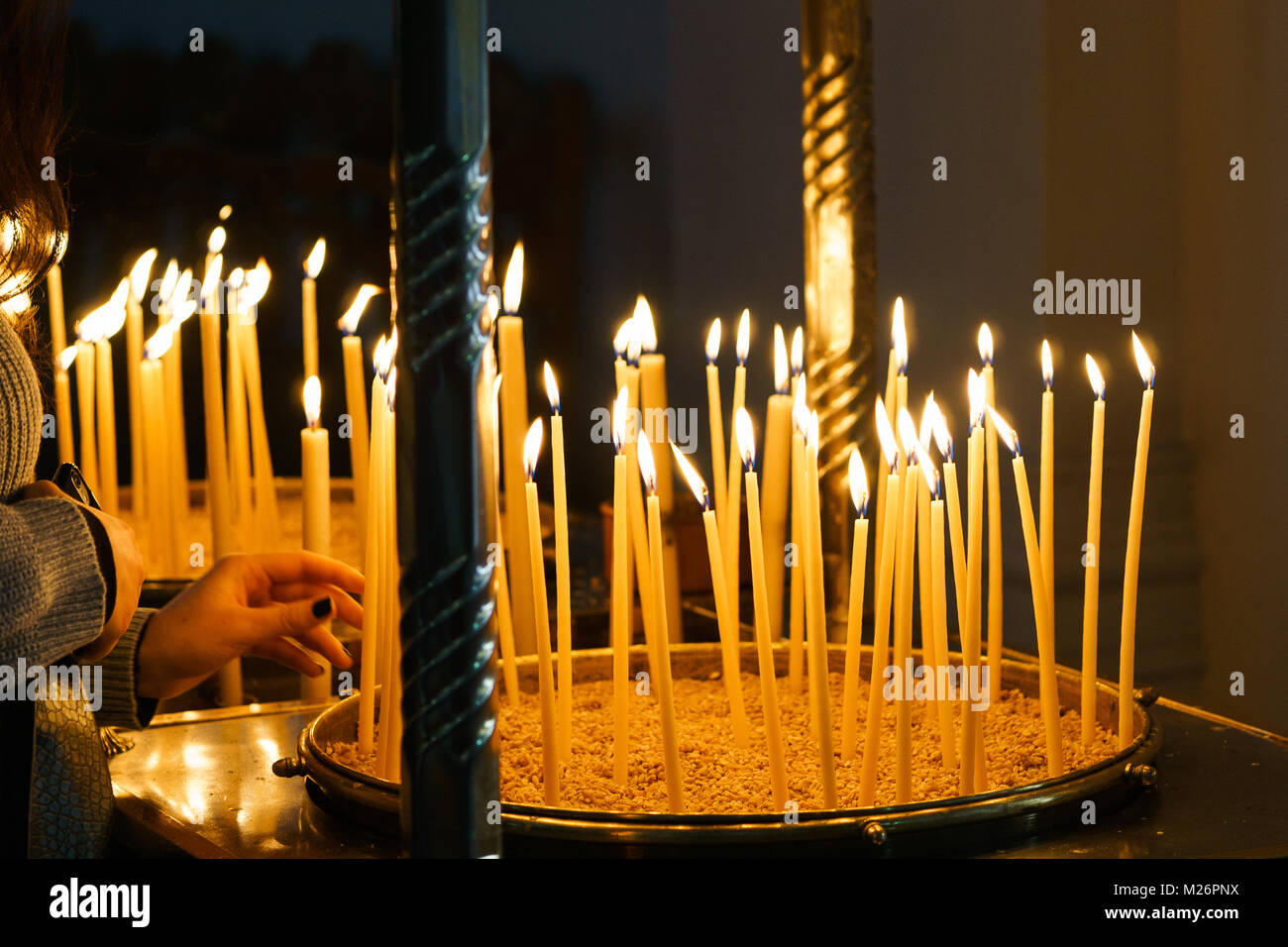 Lit candles in candlestick at church Stock Photo - Alamy