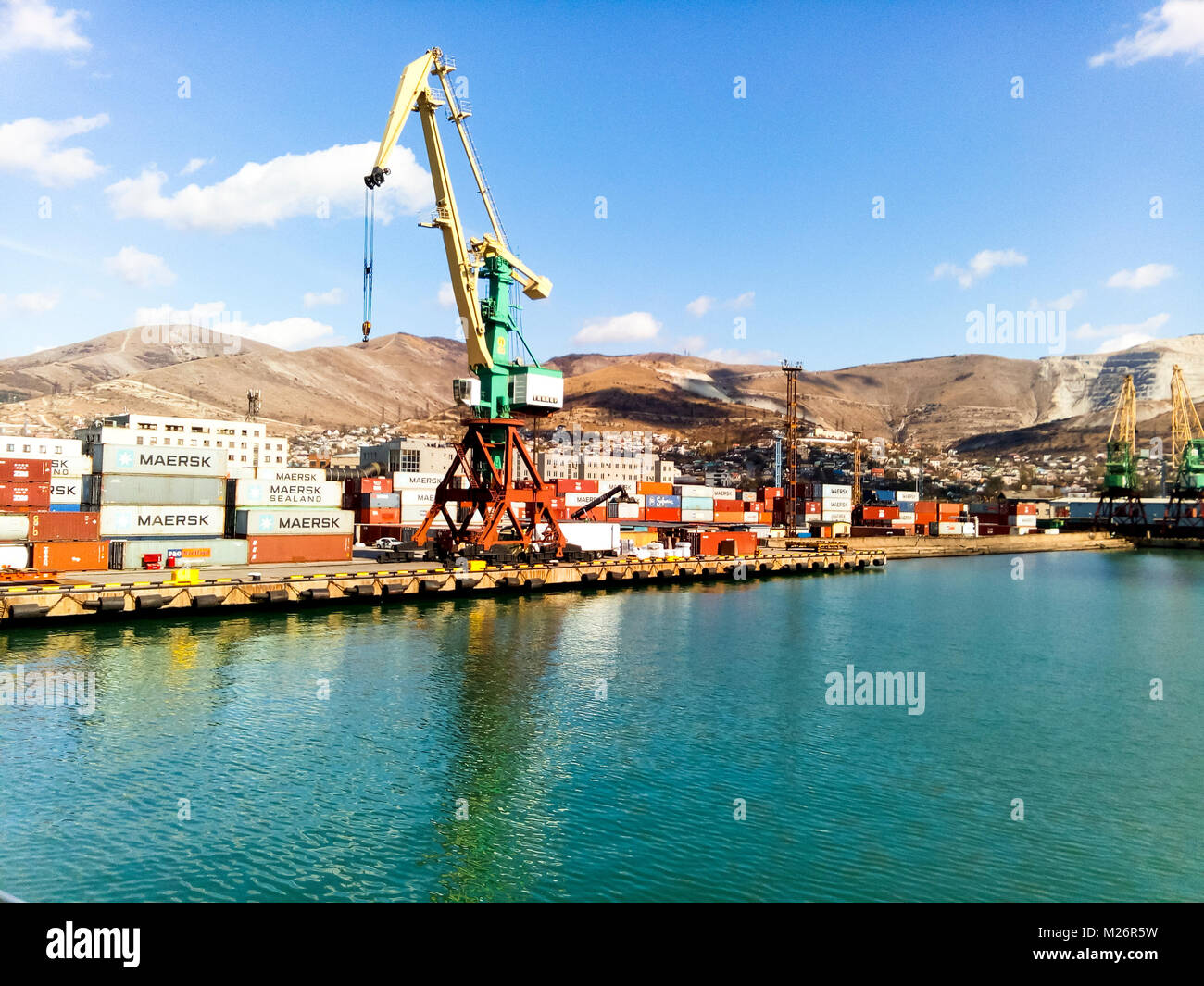 View of the sea and city beach from the port quay. Industrial port with ...