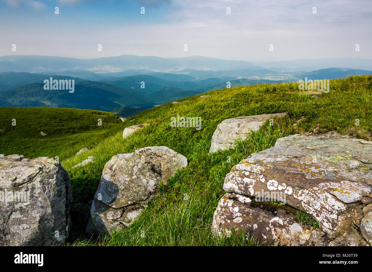 grassy slope of a hill with huge boulders. beautiful landscape of ...