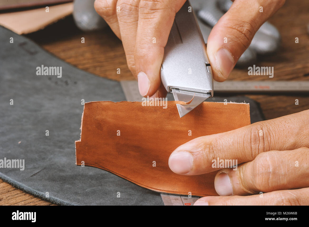 Using the retractable utility knife to cut leather Stock Photo - Alamy