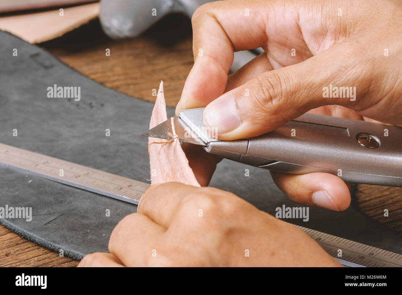 Using the retractable utility knife to cut leather Stock Photo - Alamy