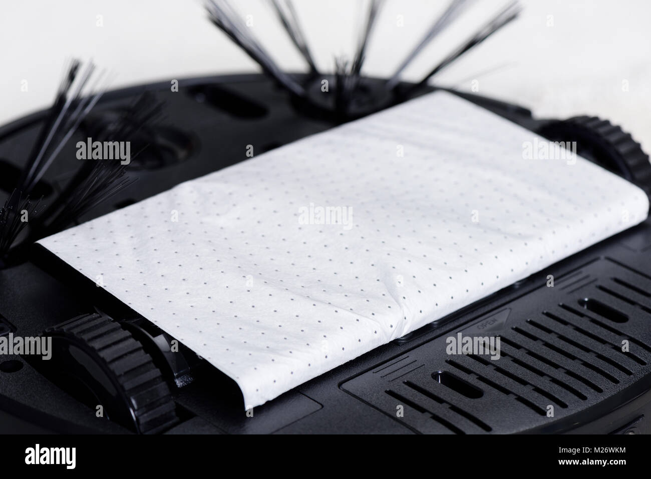 closeup dusting paper under robotic vacuum cleaner Stock Photo - Alamy