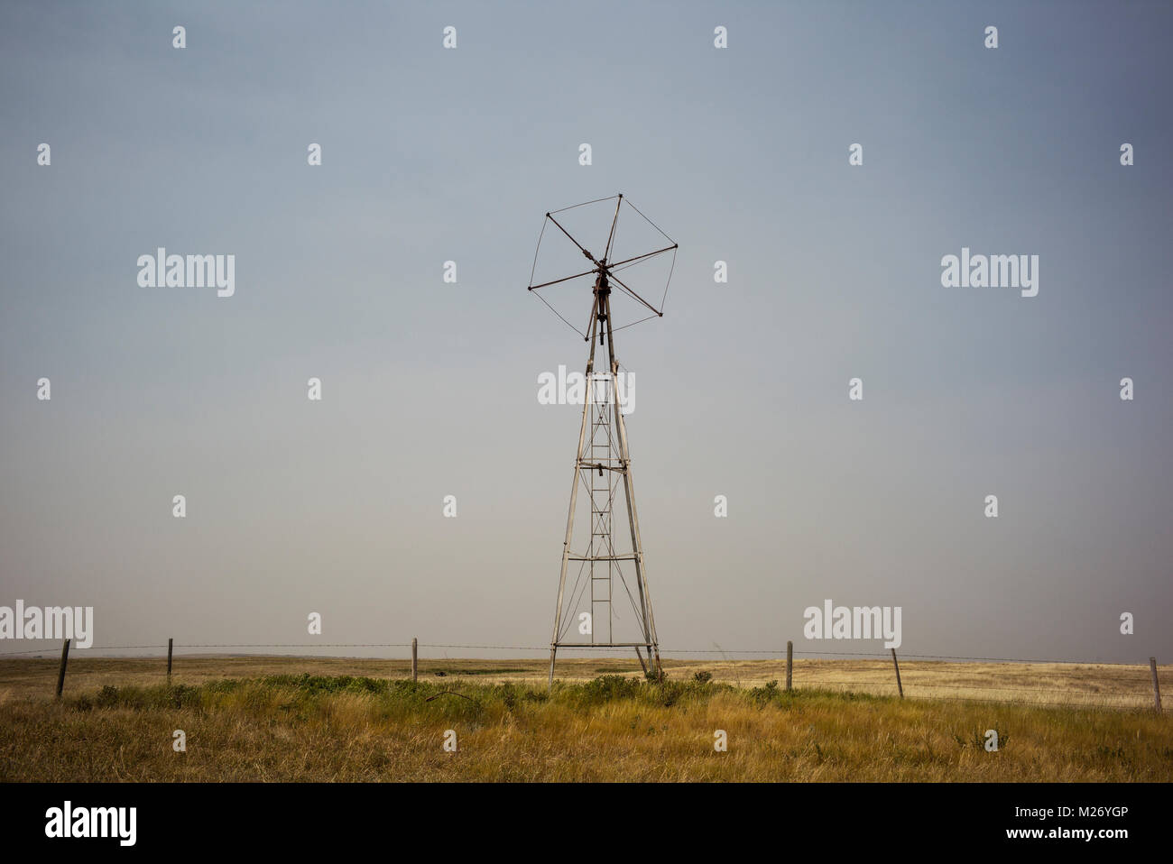 An old windmill used to pump water on the open prairie Stock Photo - Alamy