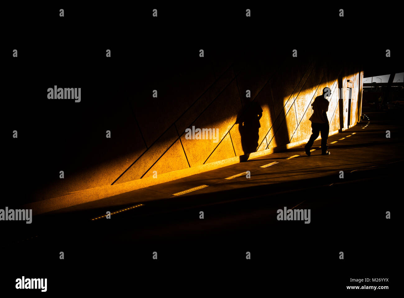 A man walks in a shaft of light during sunset Stock Photo - Alamy