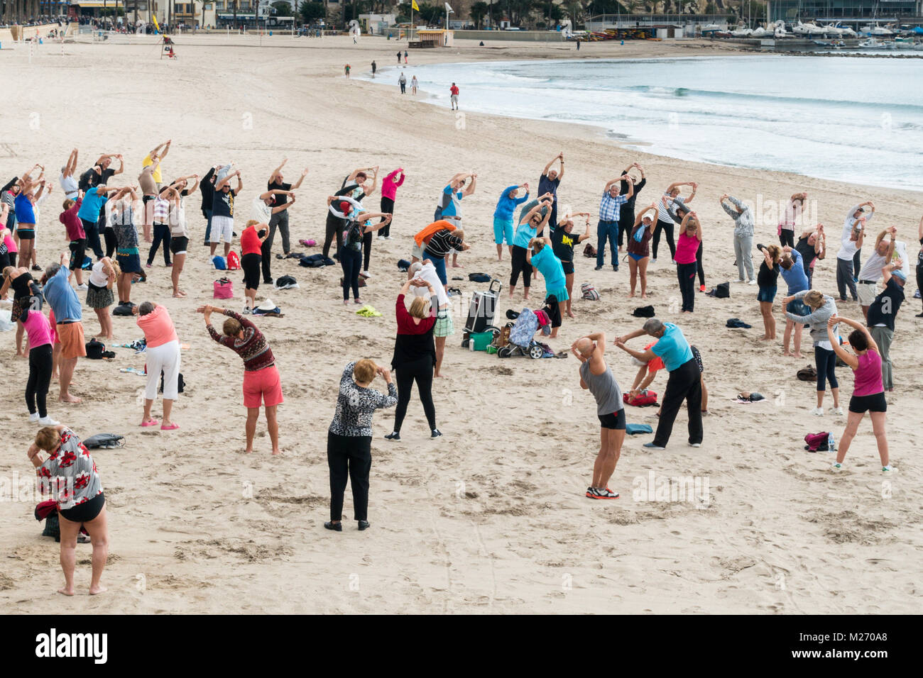Seniors keeping fit on the beach in Benidorm, Spain. Men women oap's ...